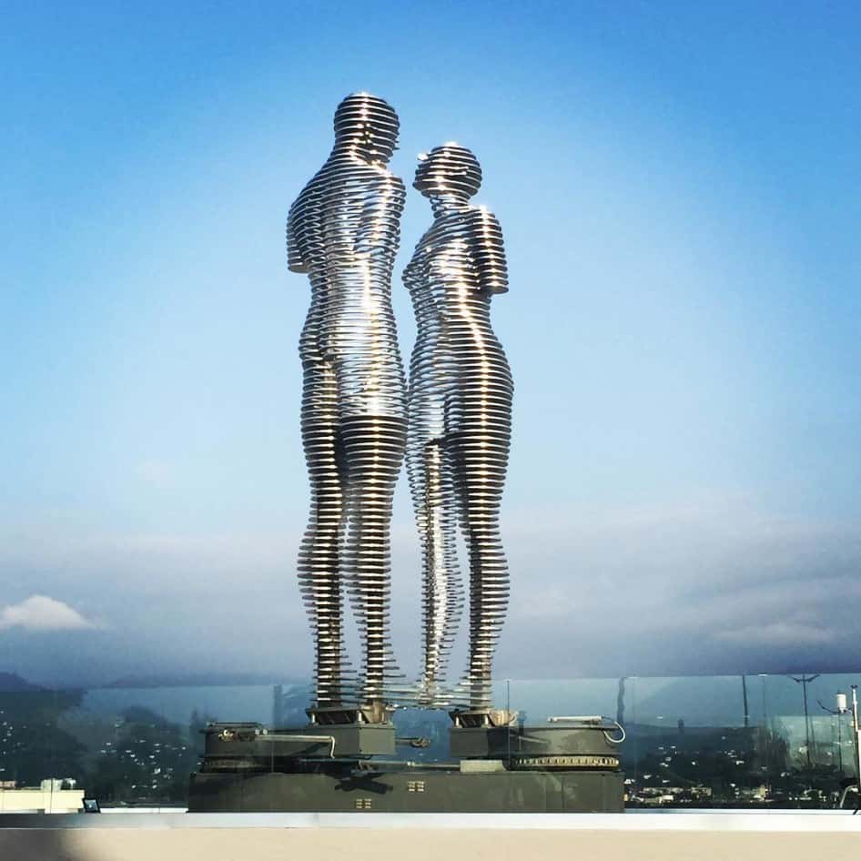 Moving Statues Of Man And Woman Passing Through Each Other Depict