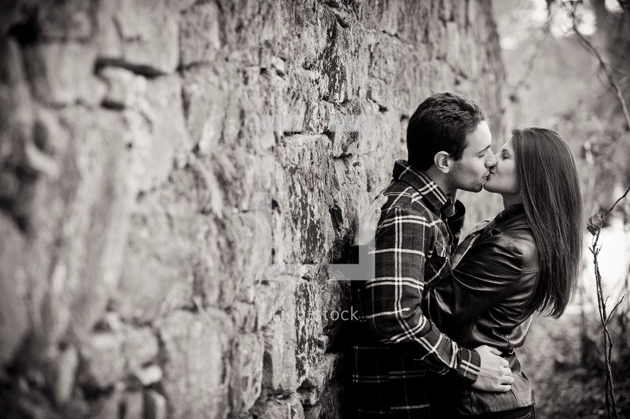 A Couple Kissing Leaning Against A Wall — Photo — Lightstock