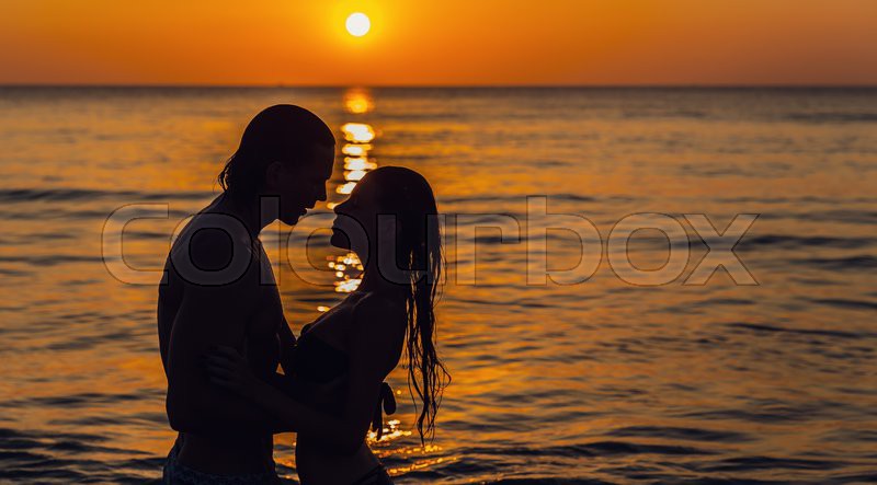 At Sunset Young Couple Embracing On The Stock Image Colourbox