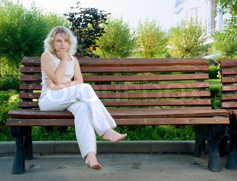 Junge Frau Sitzt Auf Der Bank In Stadtpark Stockfoto Colourbox