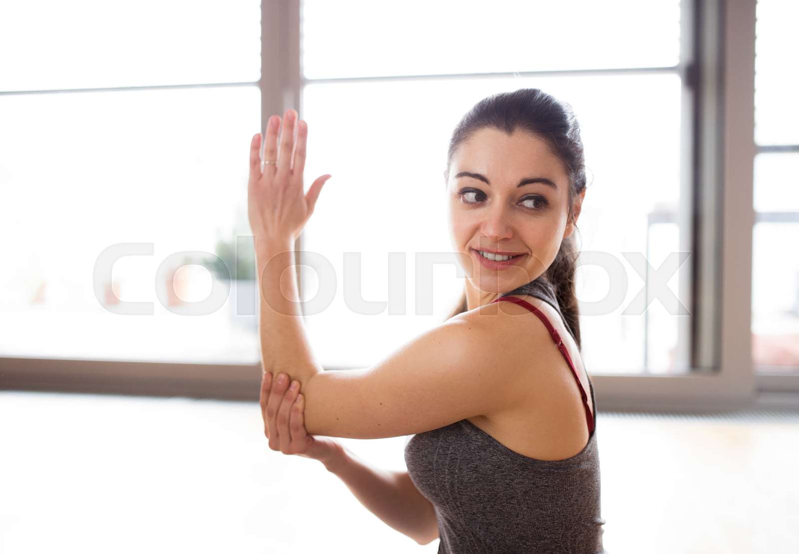 Young Woman Exercising At Home Stretching Arms Stock Image Colourbox