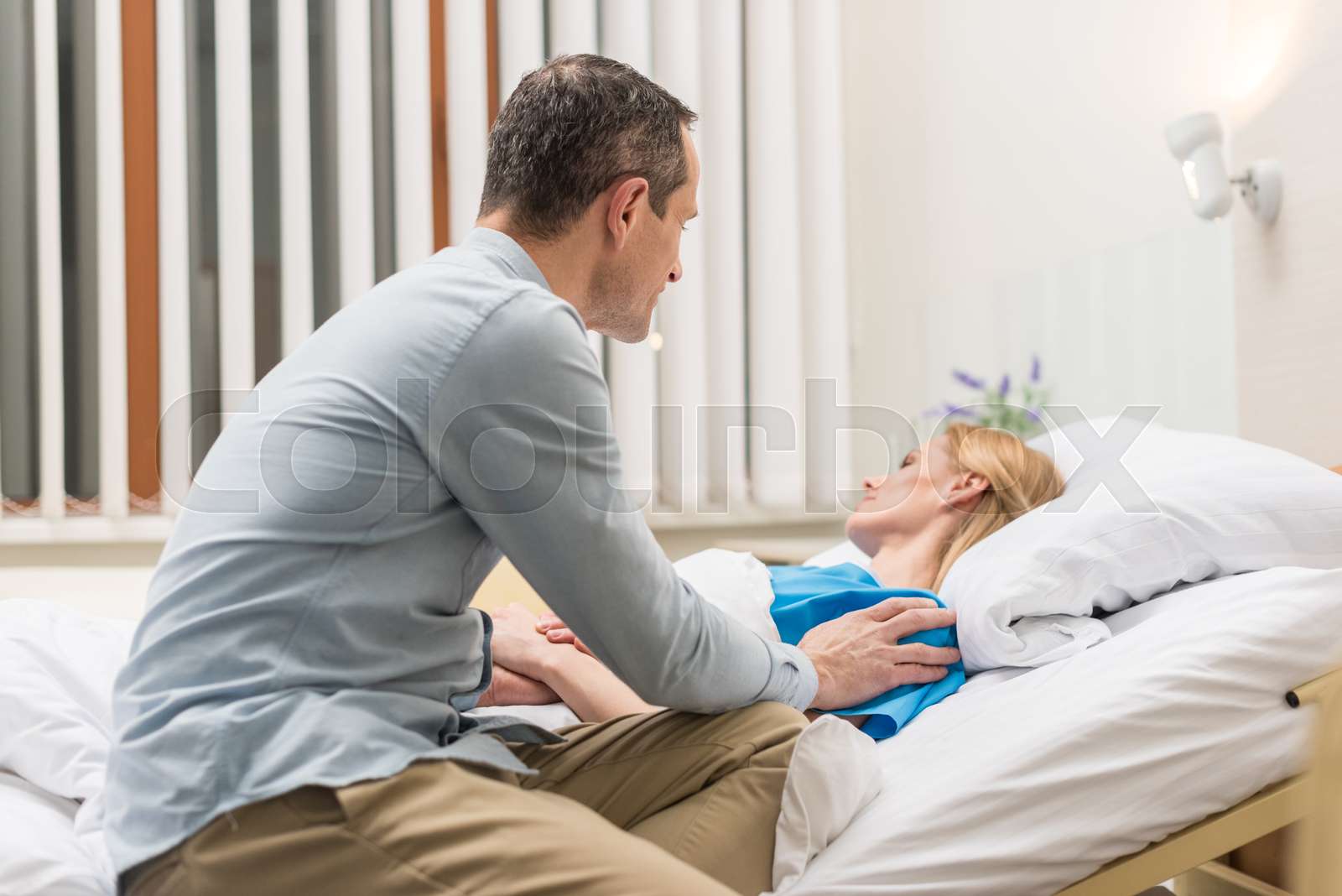 Husband Sitting At Sick Wife Bed In Hospital Stock Image Colourbox