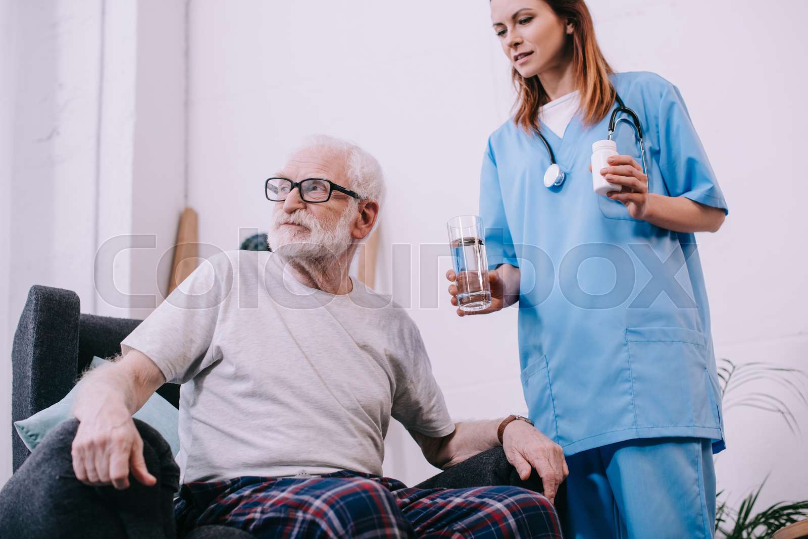 Senior Patient Refusing To Take Medications From Nurse Stock Image