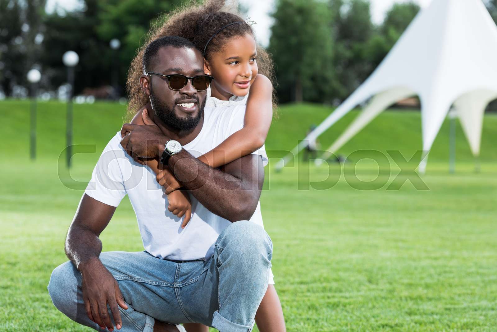 African American Daughter Hugging Father From Back In Park And They