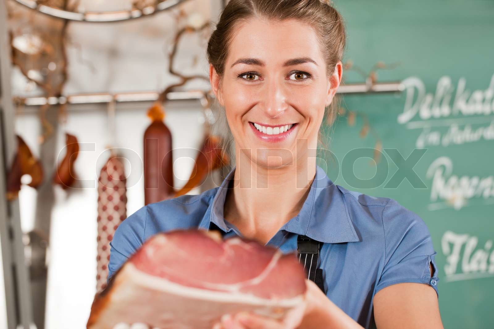 Woman Or Female Butcher With Raw Ham In Butchers Shop Stock Image