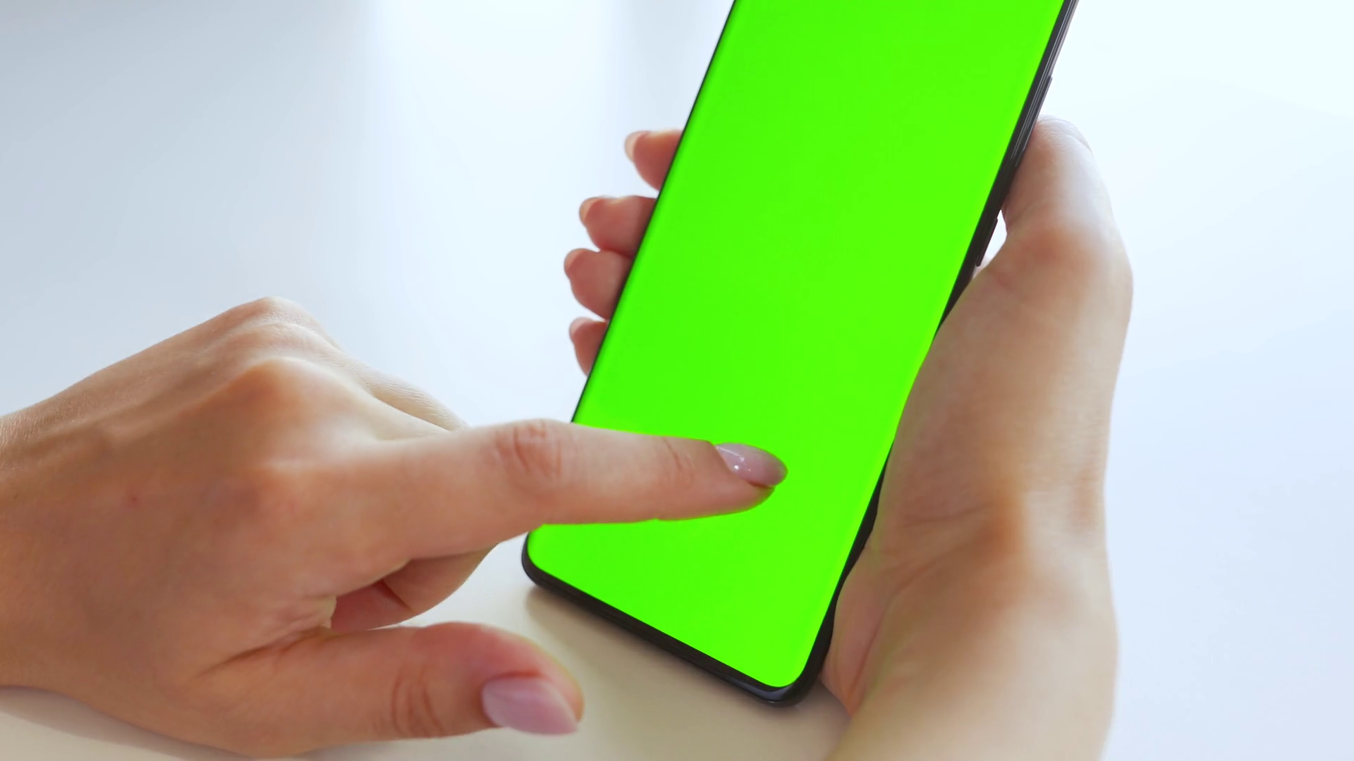 Female Hands Using A Smartphone With A Green Screen In Vertical Mode