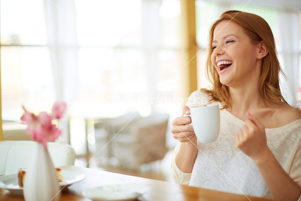 Young Woman Enjoying Coffee In A Cafe Royalty Free Stock Image