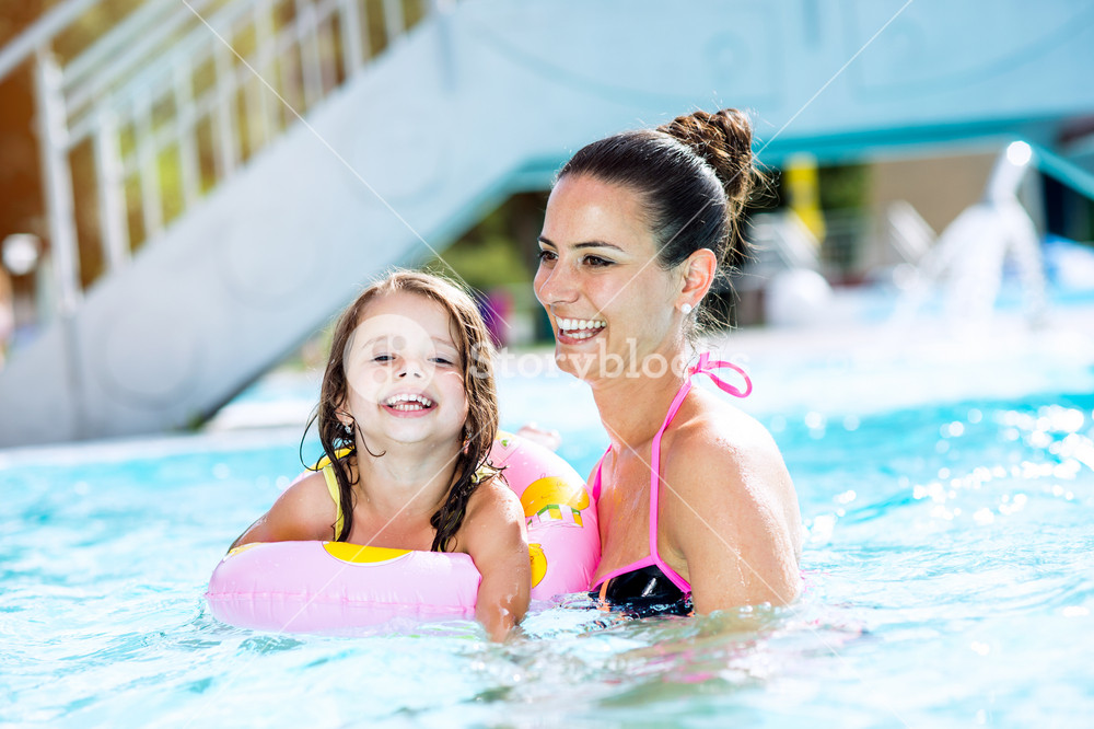 Young Beautiful Mother In Bikini Playing With Her Daughter In